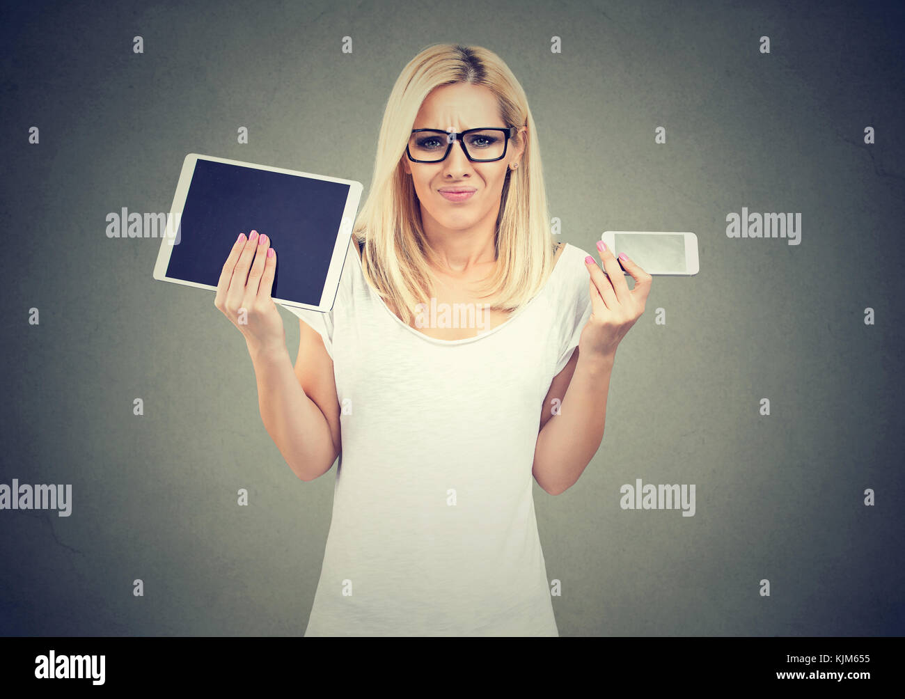 Perplexed woman in glasses shrugging shoulders uncertain what to choose ...