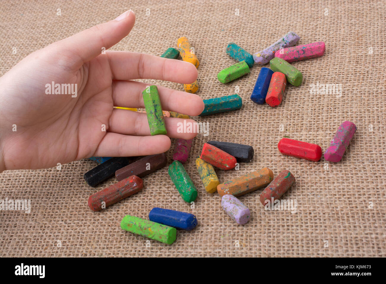 Used color crayons and a hand holding one Stock Photo - Alamy
