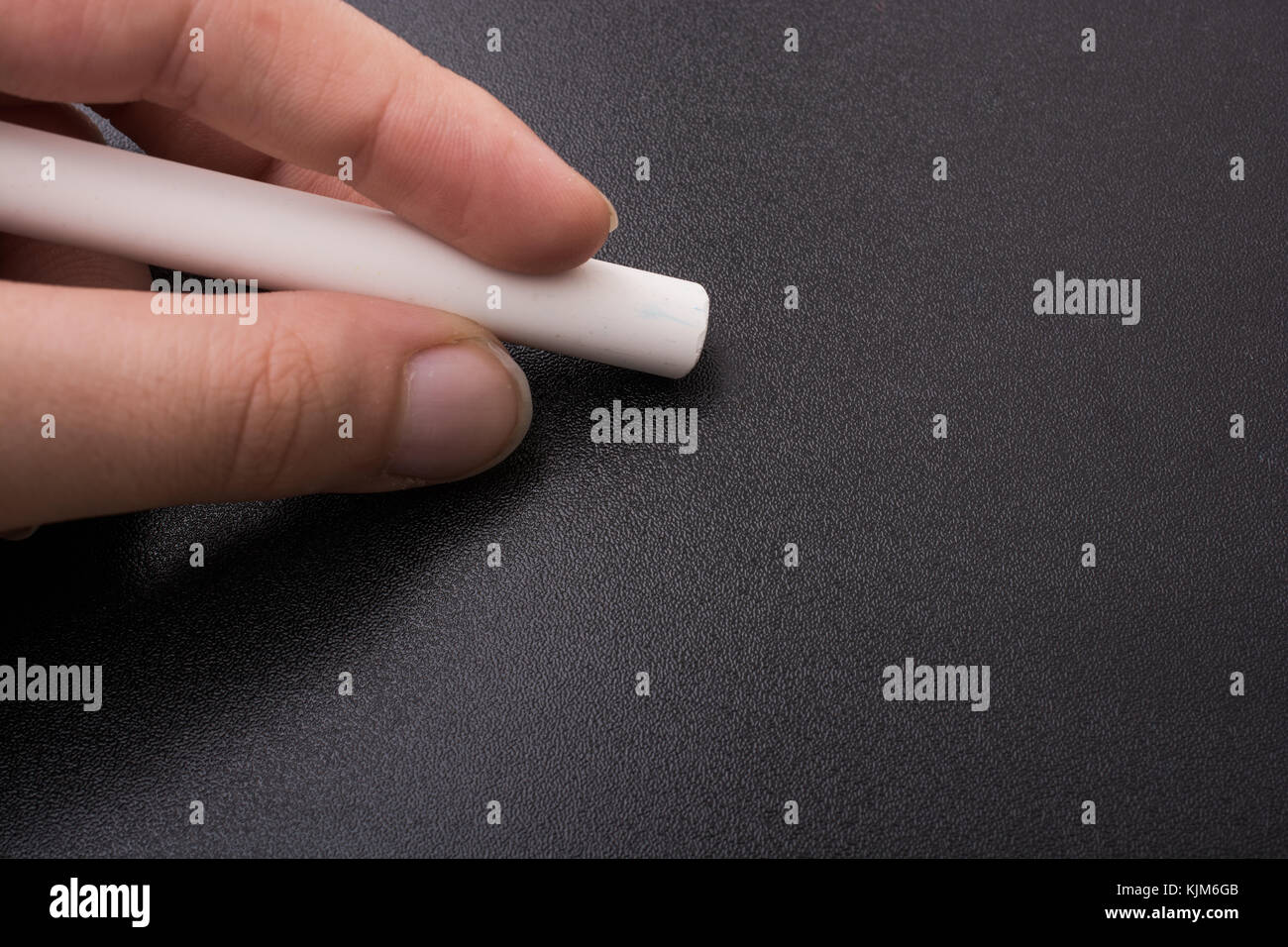 Hand holding white chalk and black board Stock Photo - Alamy