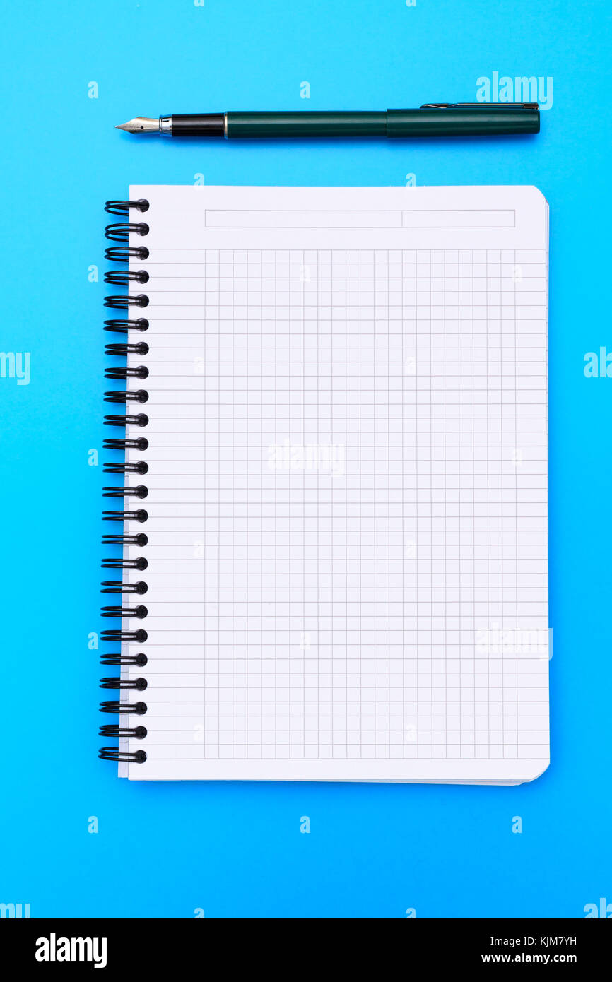 Top view on a blank notebook with pen flat lay on blue background Stock ...