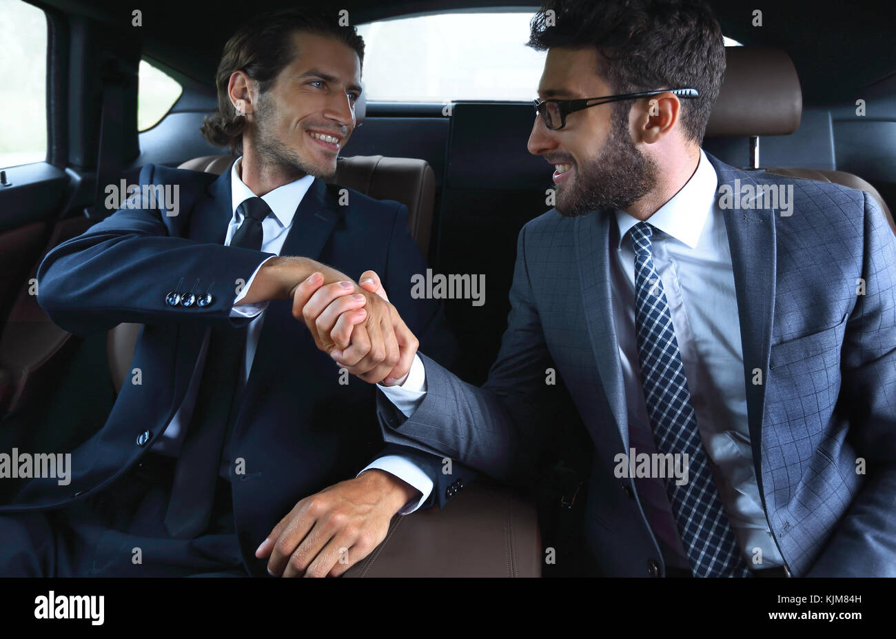 handshake of business partners sitting in the car Stock Photo - Alamy