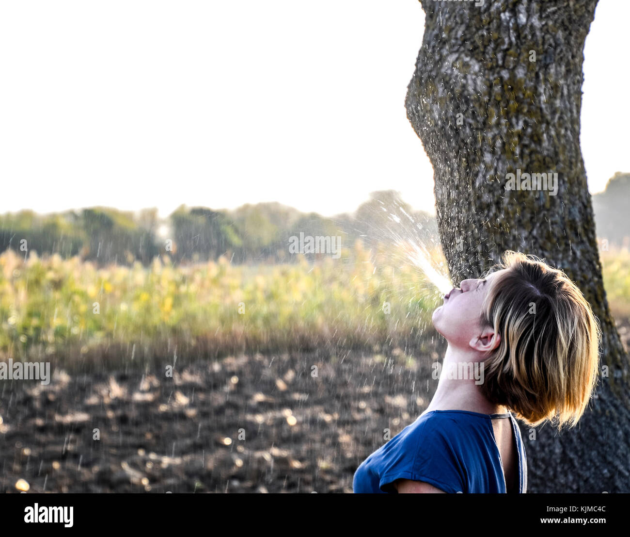 The girl spits out the water. Fountain of water from the girl's mouth ...