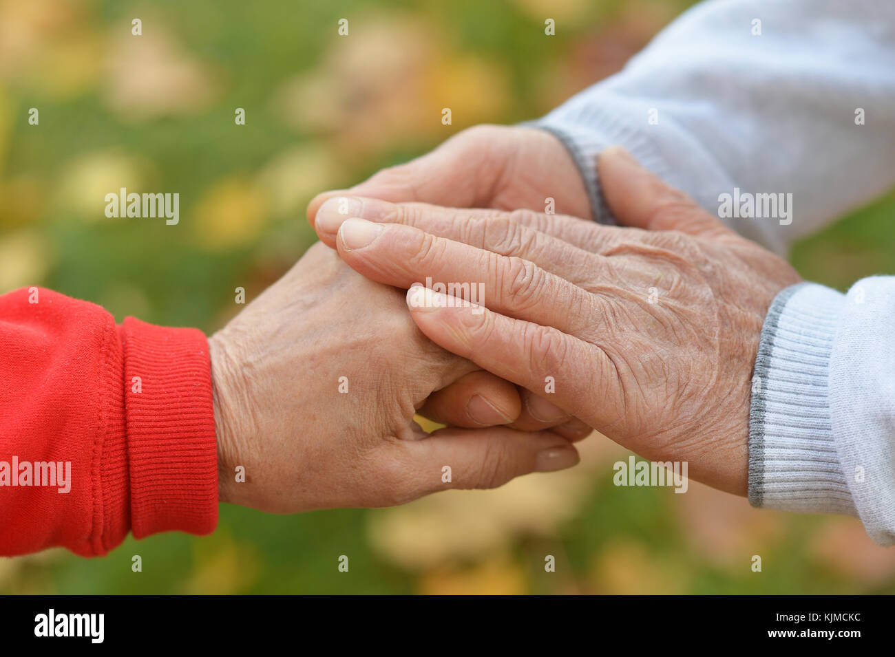 Elderly couple holding hands Stock Photo - Alamy