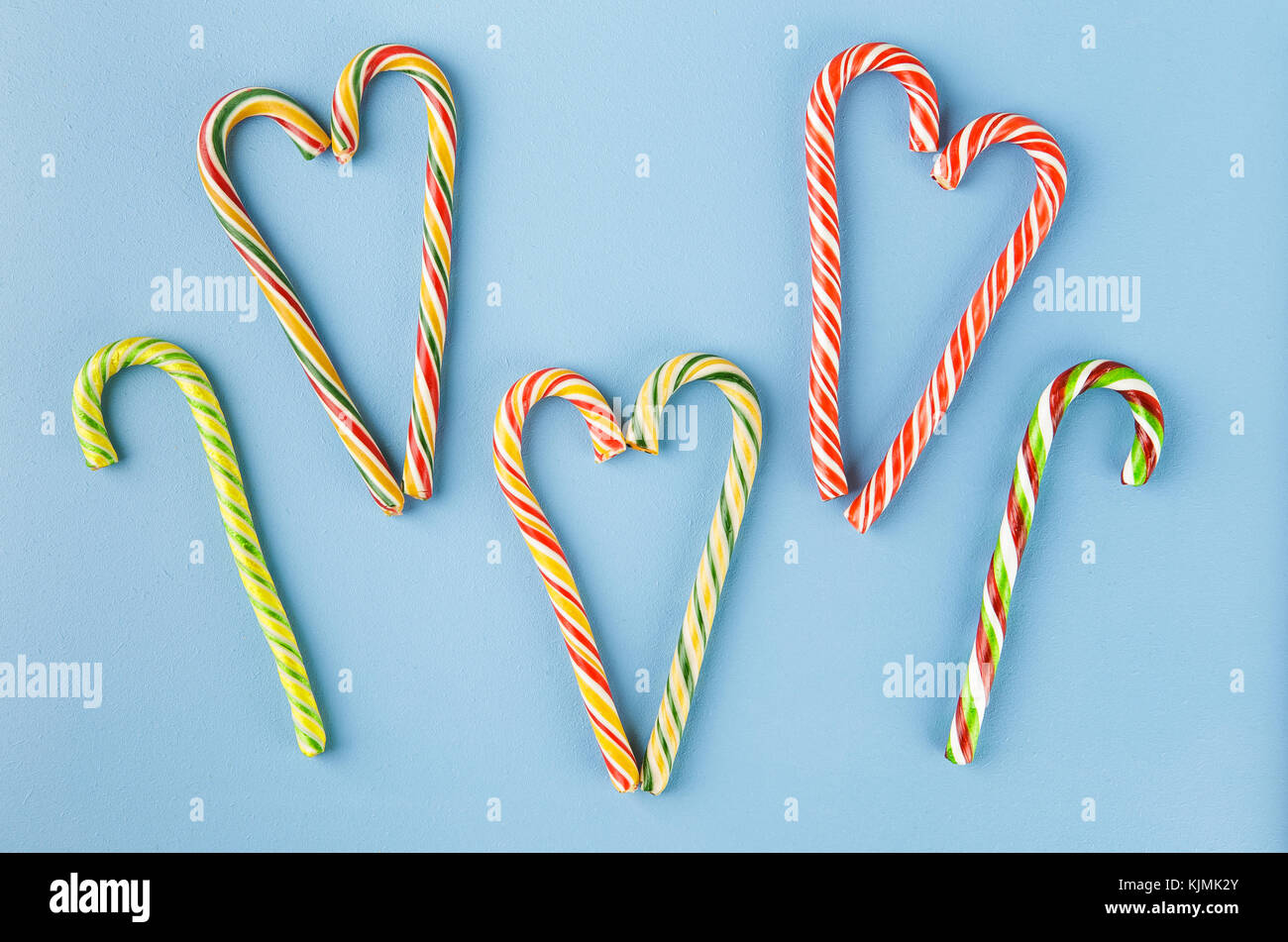 Sweet Candy canes hearts on blue background. Flat lay. Top view Stock ...