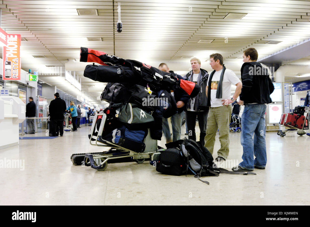 group of men with skis and a baggage trolley in the arrivals concourse ...