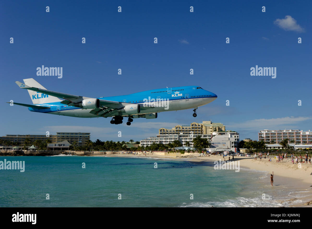flying low on final-approach landing over Maho Beach with hotels behind ...