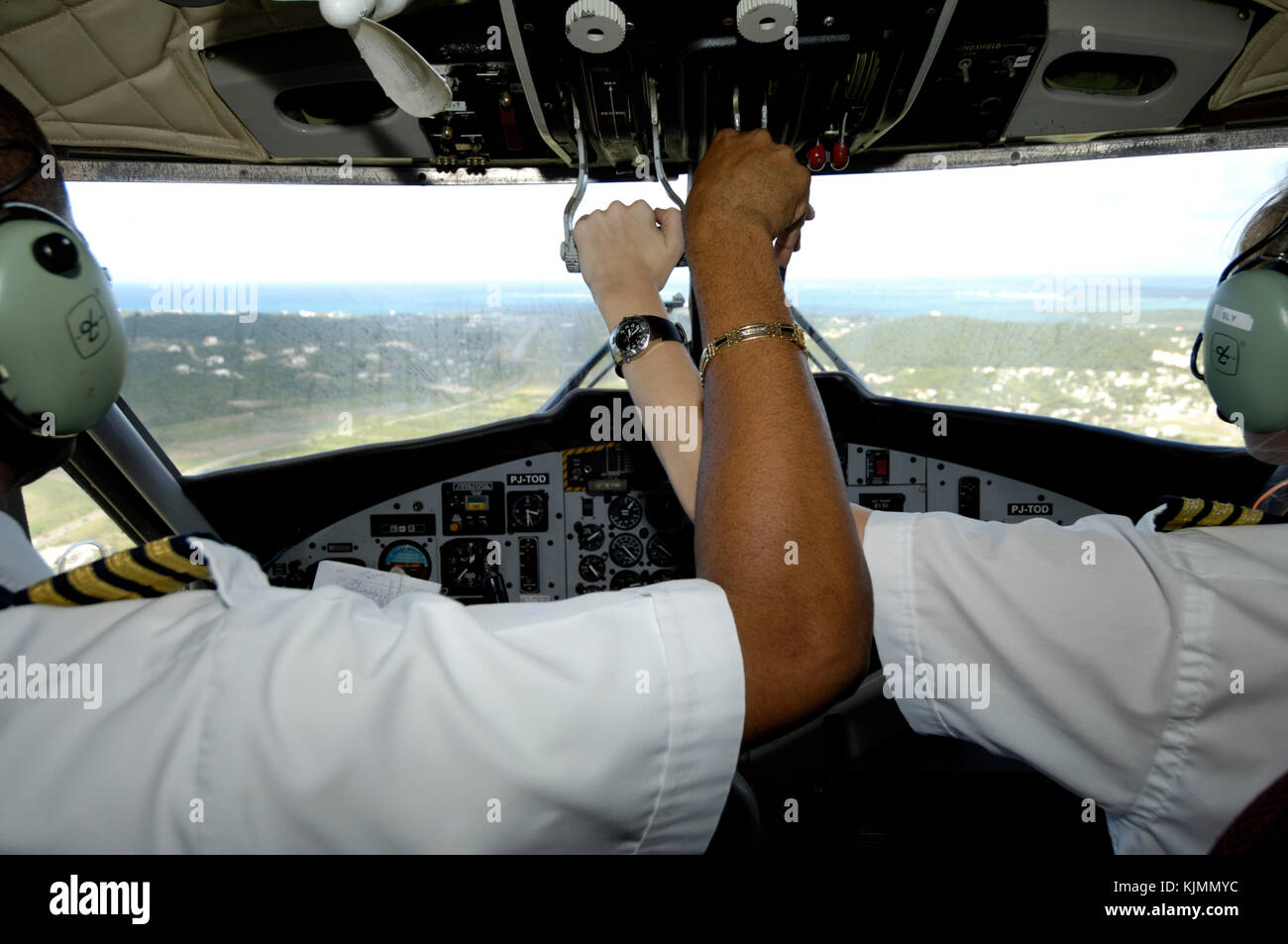 A female co-pilot with hand on throttles and a male captain with arms ...