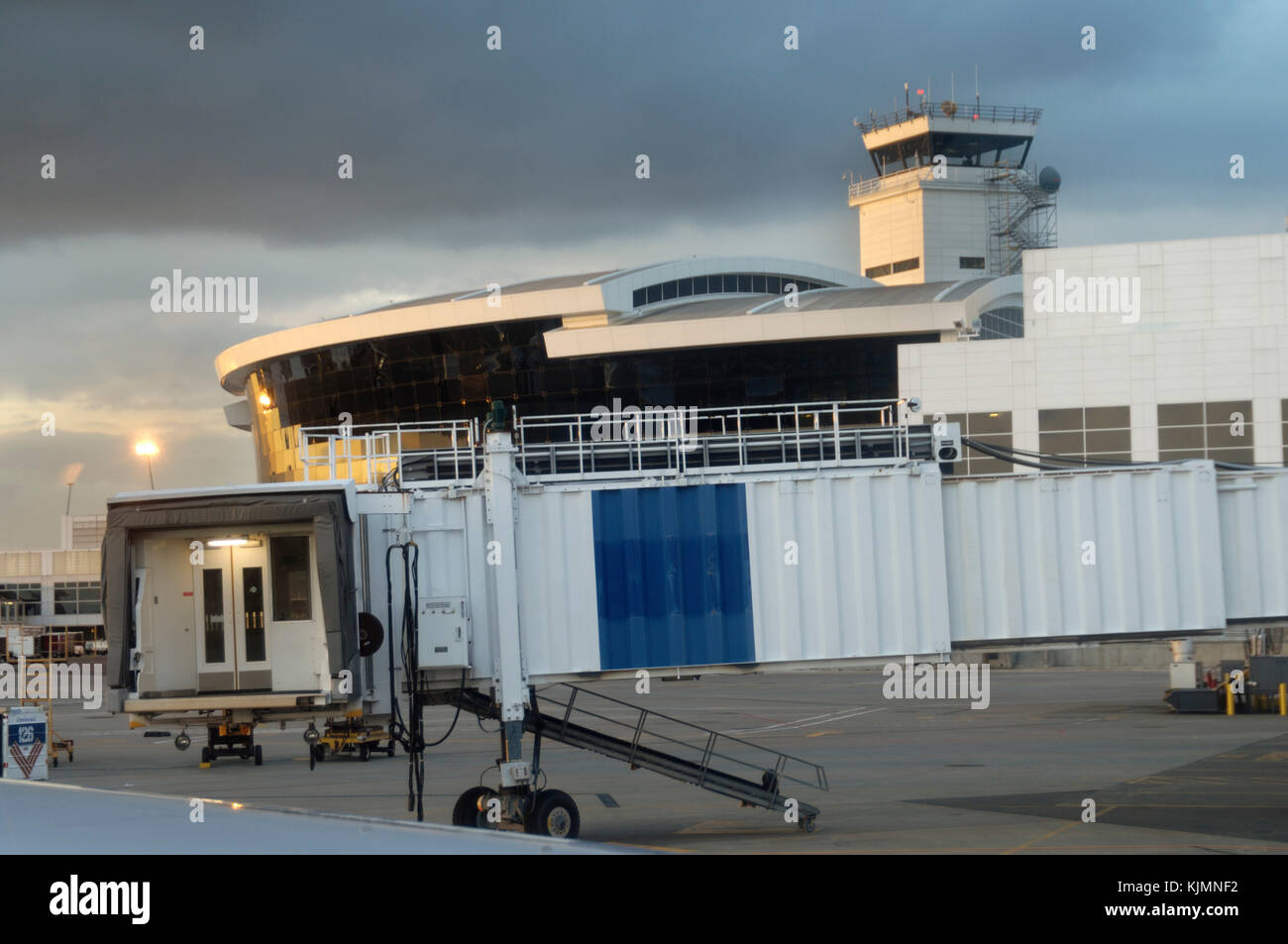 terminal building with jetway extended and an air traffic control-tower ...