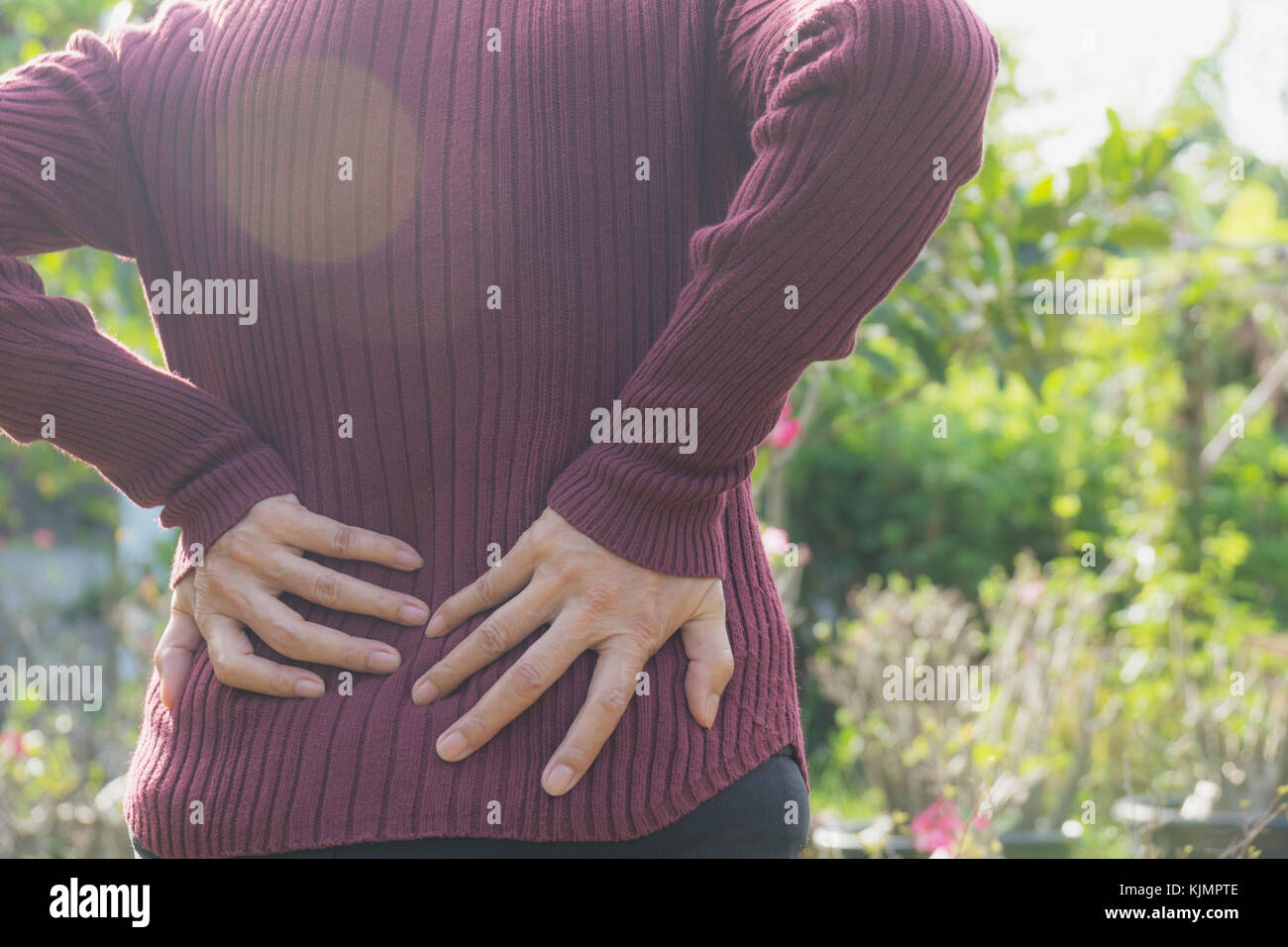 A woman suffering from backache, spinal injury and muscle issue problem ...