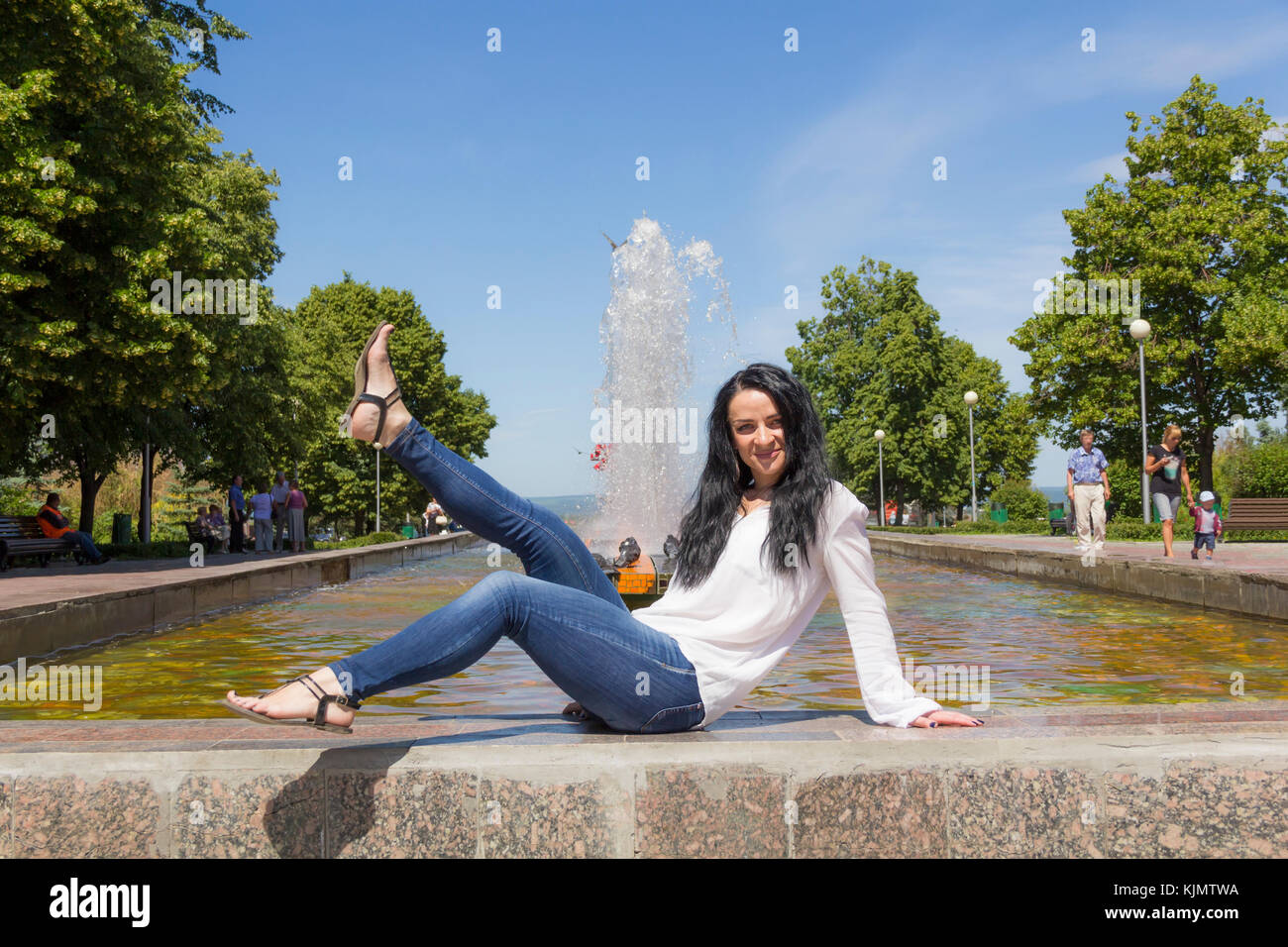 Caucasian brunette with upward legs on fountain background Stock Photo ...