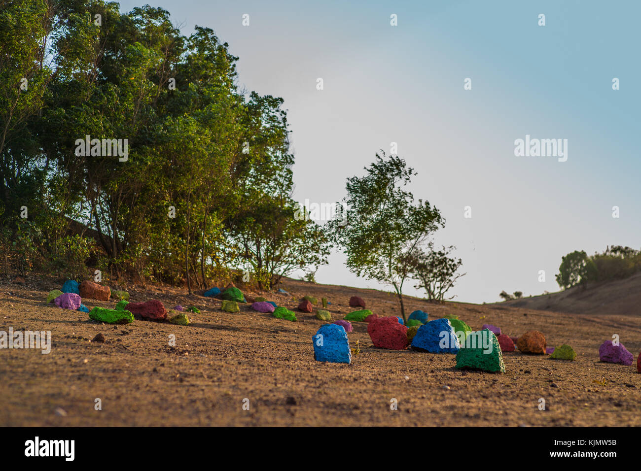 A field in Goa, India, with some painted rocks Stock Photo - Alamy
