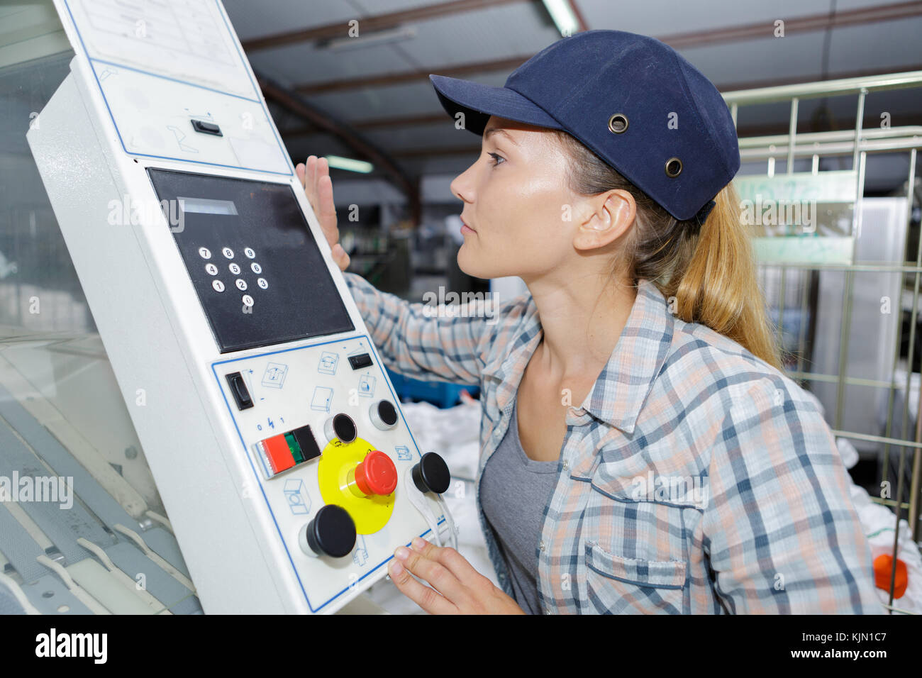 female worker operating machinery at control panel in factory Stock ...