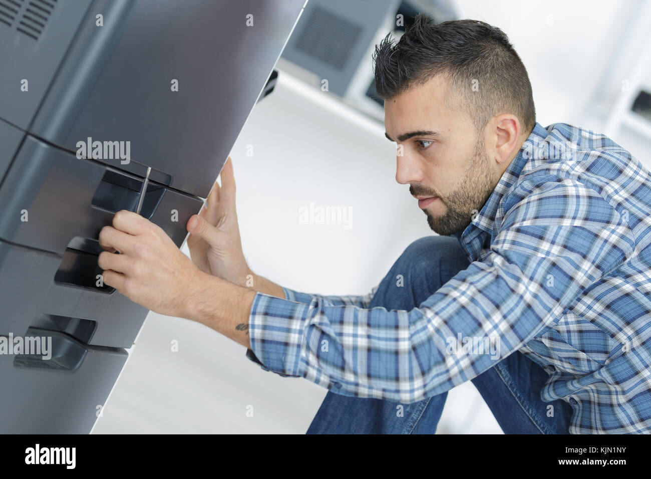 man with screwdriver in hand fix printer Stock Photo - Alamy