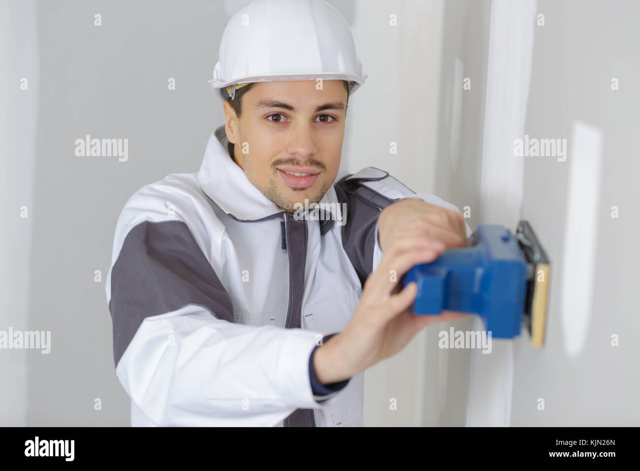 Portrait of young worker using sander Stock Photo - Alamy