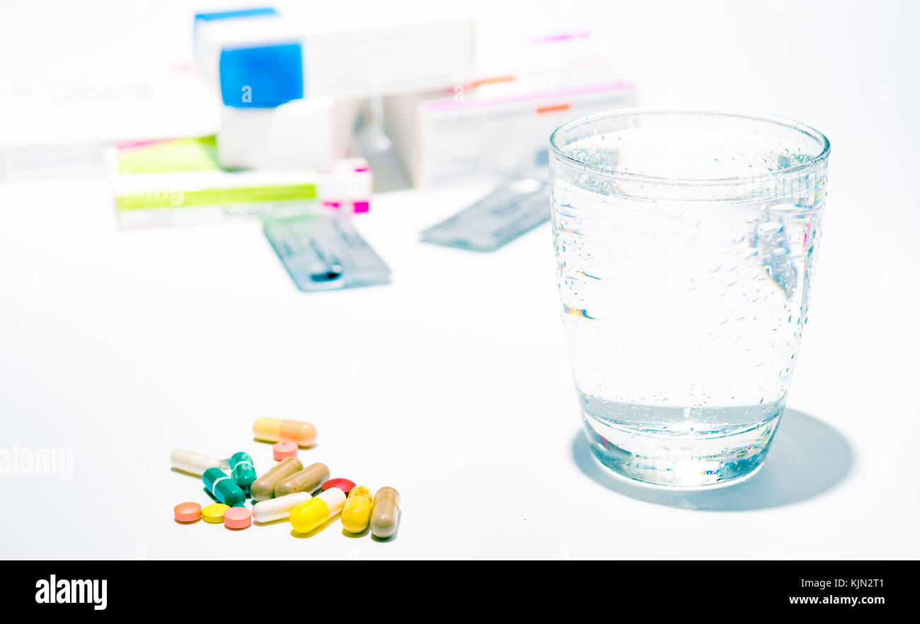 Tablets and medicines and a glass of water Stock Photo - Alamy