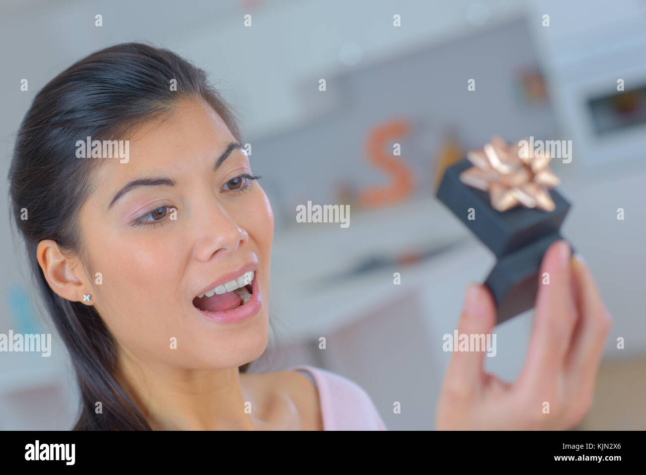 beautiful woman opening a small present Stock Photo - Alamy