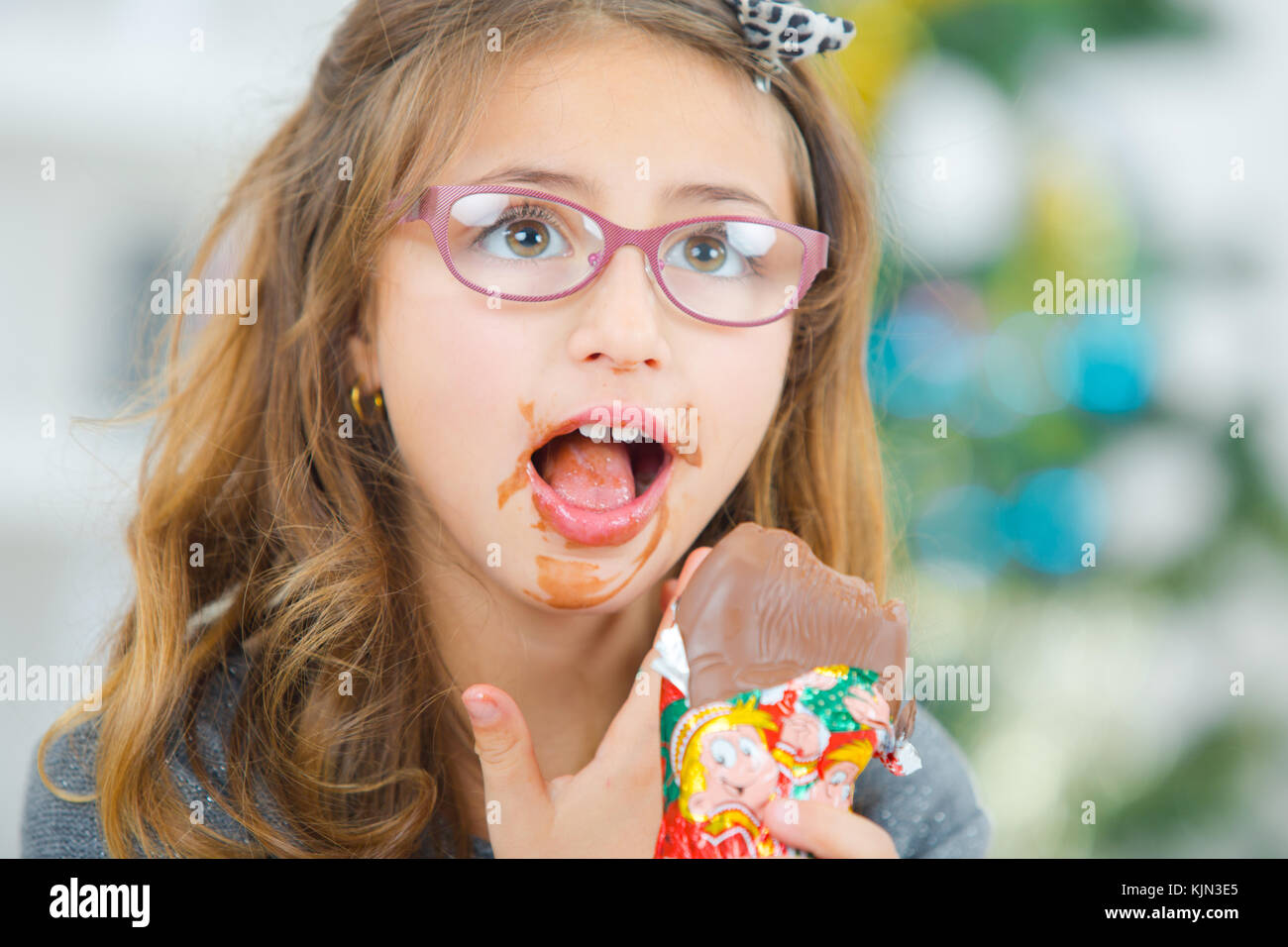 Little girl eating chocolate at Christmas Stock Photo - Alamy