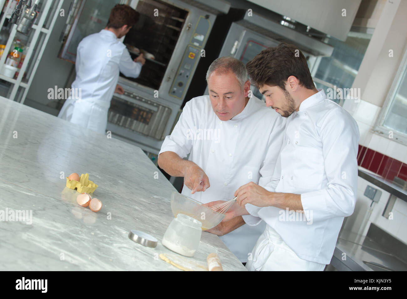chef and apprentice making pastry Stock Photo - Alamy