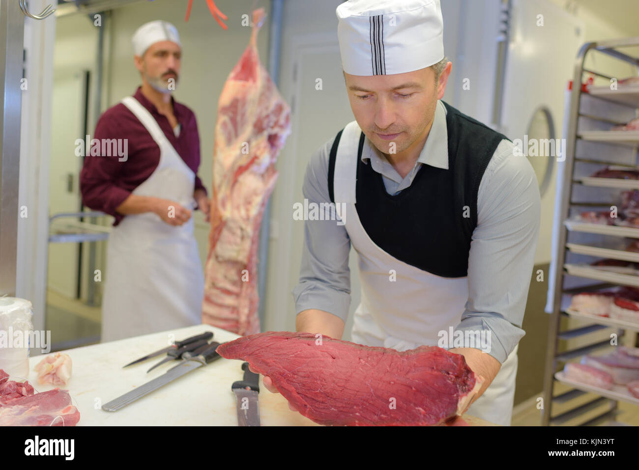 Butcher holding meat Stock Photo - Alamy