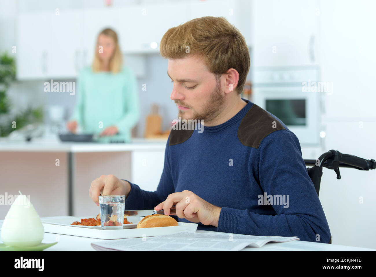 Disabled man sat at a dining table Stock Photo - Alamy