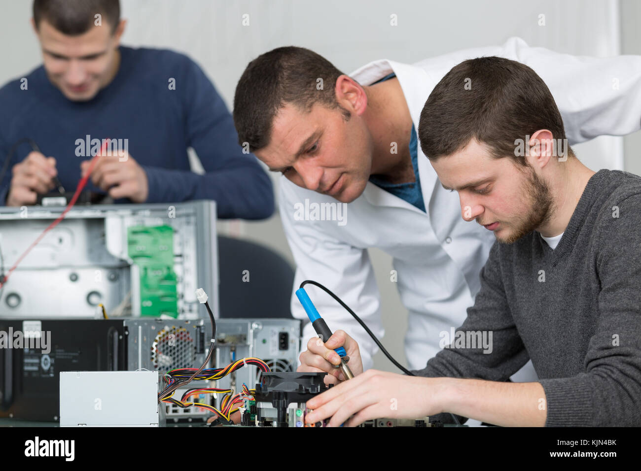 apprentice male technician soldering lan switch router Stock Photo - Alamy