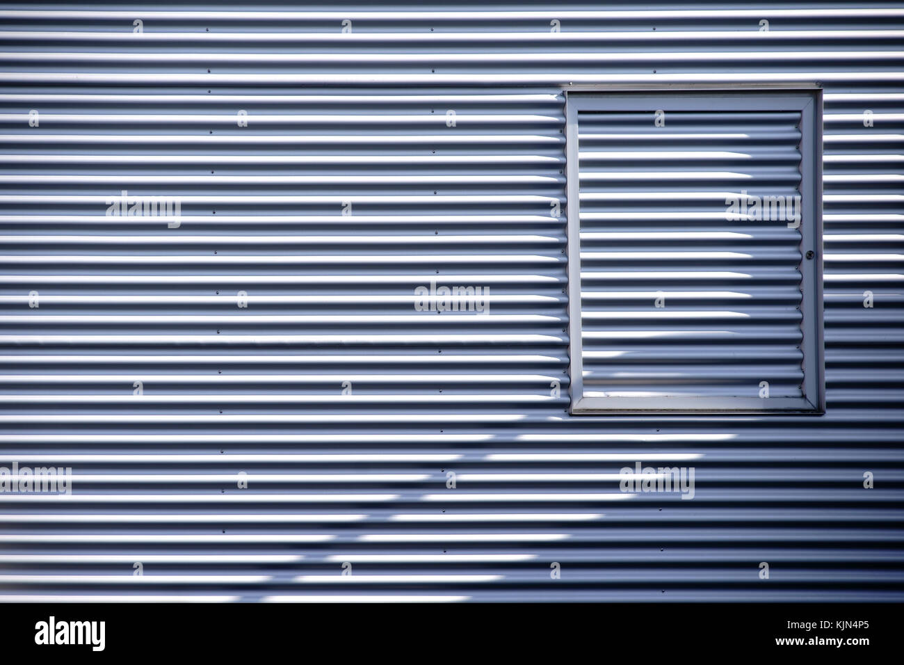 The detail of a modern facade of corrugated metal with a grate window ...