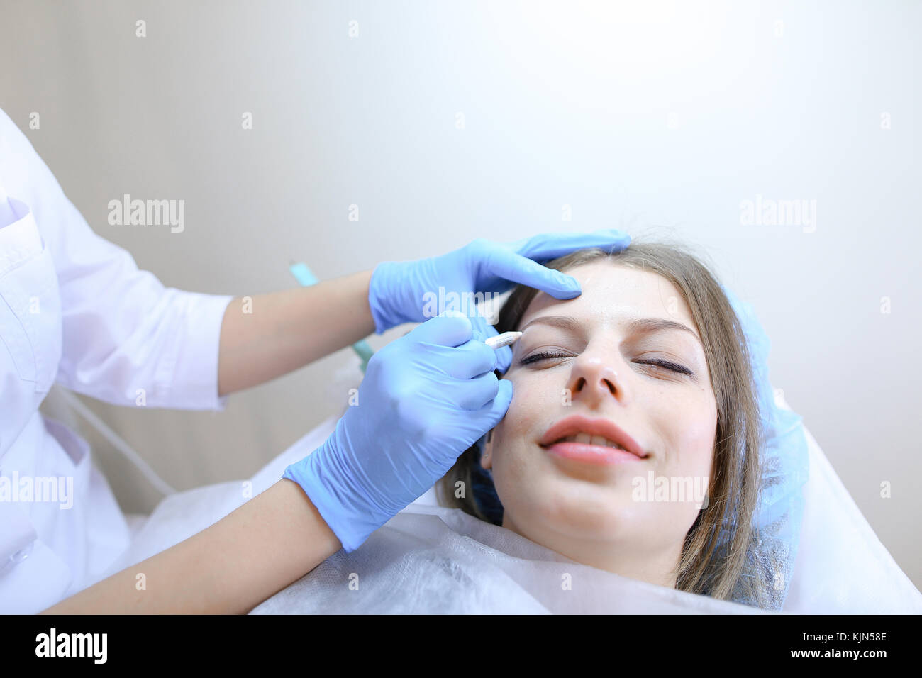 Professional female master of manual tattoo engaged in adjusting Stock ...