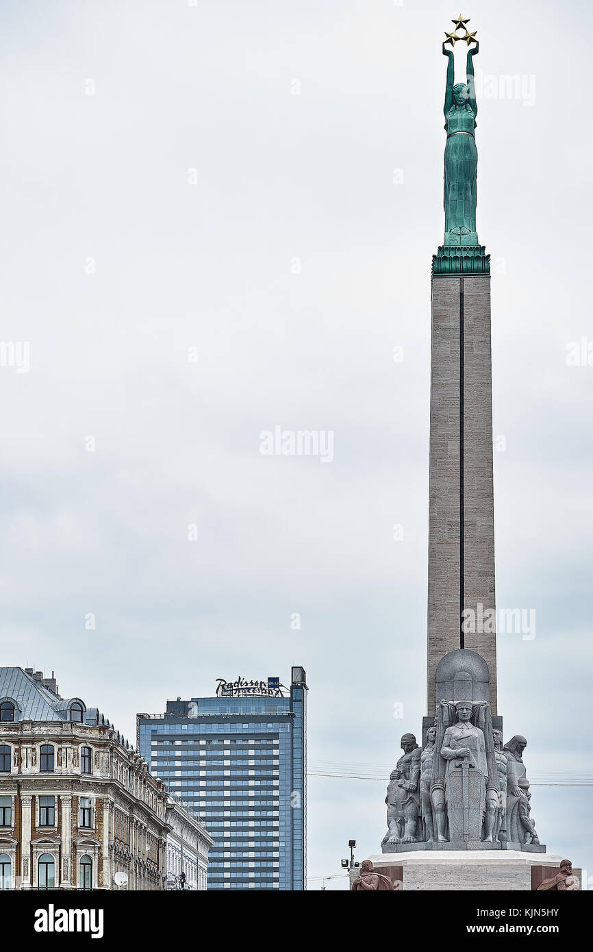 Monument of freedom in Riga. Woman holding three gold stars that ...