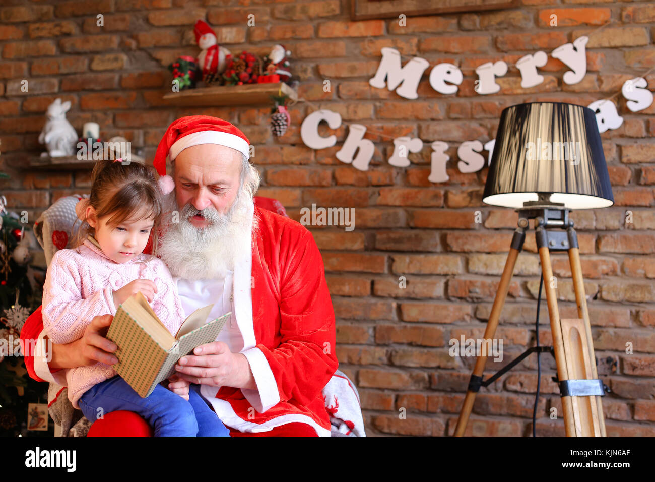 Young person girl shows Santa Claus interesting pictures in lar Stock ...