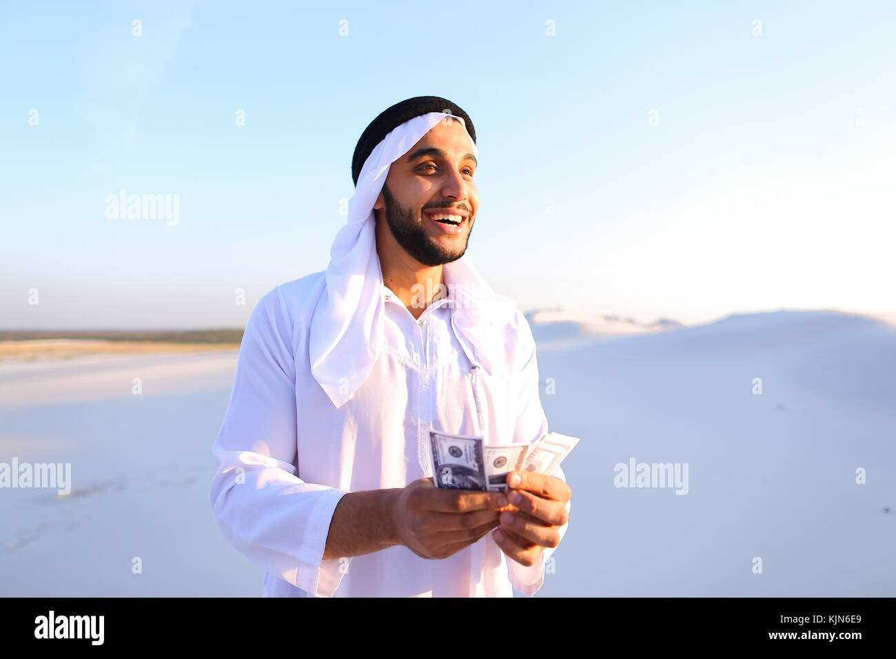 Successful Arab sheikh considers banknotes and happy, standing i Stock ...