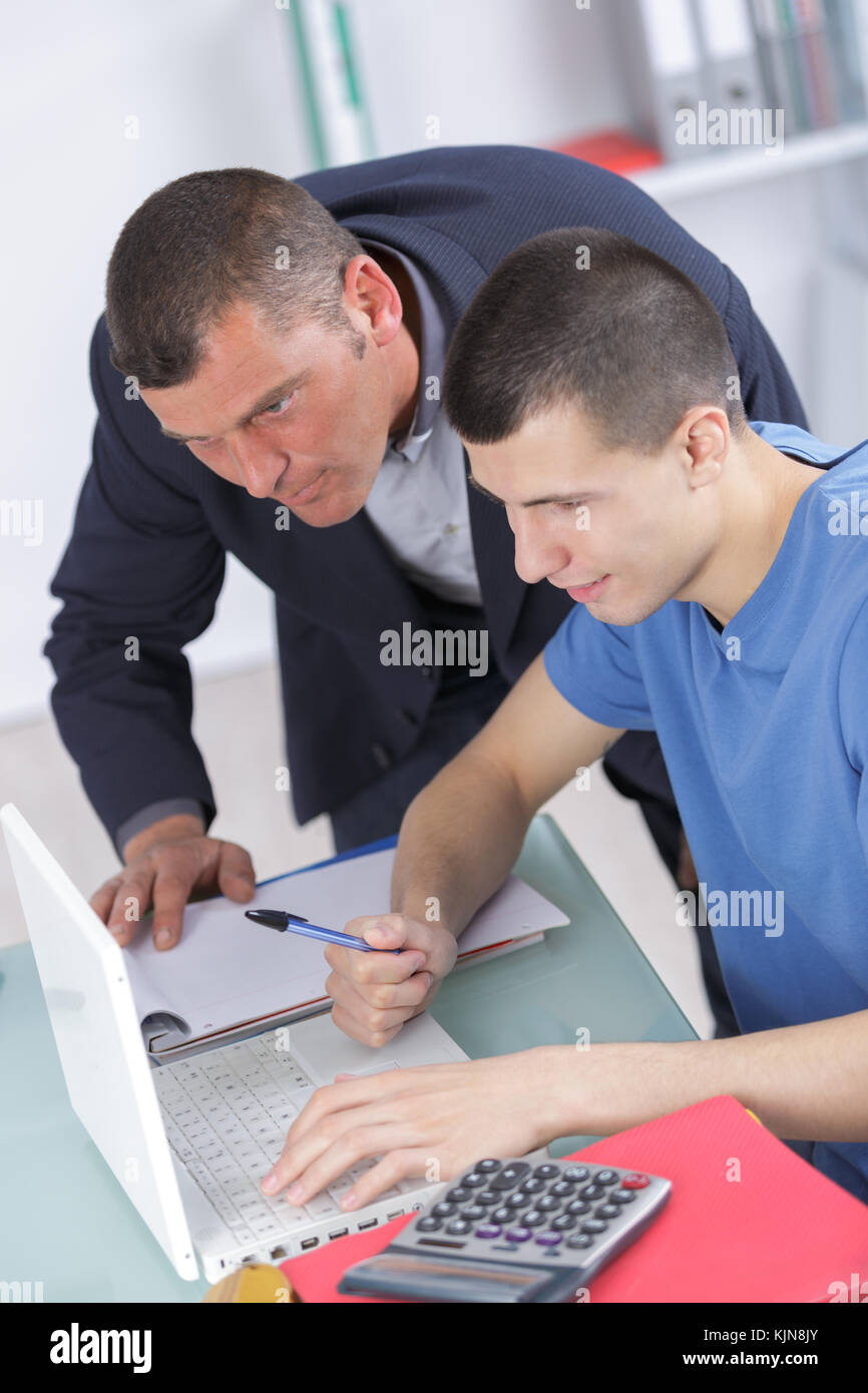computer teacher assisting a student in classroom Stock Photo - Alamy
