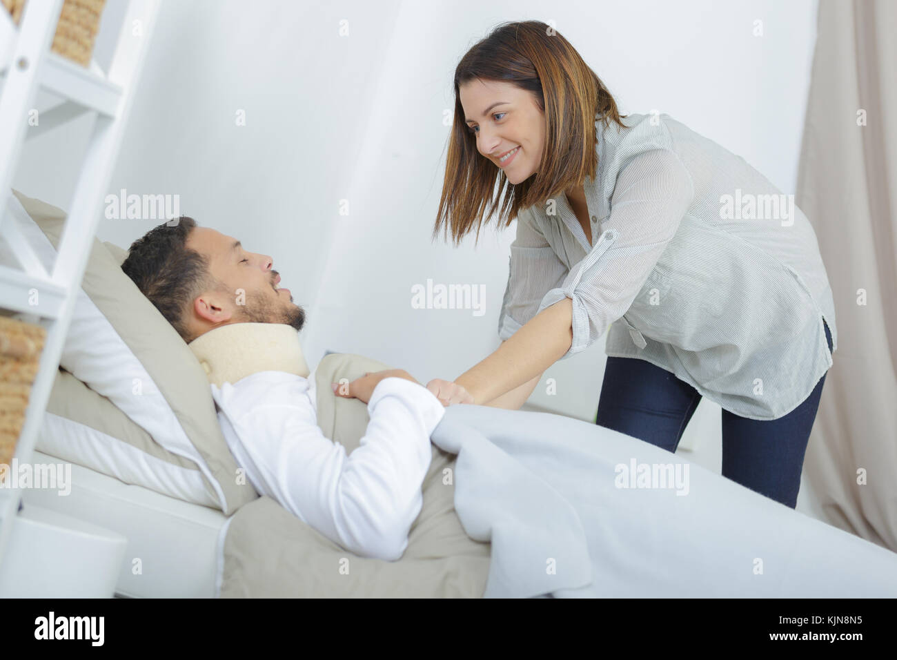 woman caring for sick boyfriend on bed Stock Photo - Alamy