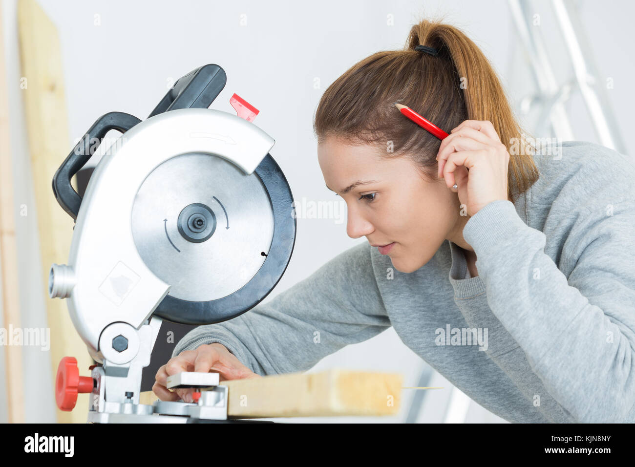 Carpenter putting pencil behind ear Stock Photo - Alamy