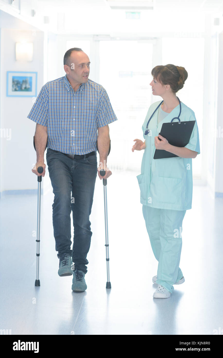 male patient with cast and surgeon walking on hospital corridor Stock ...