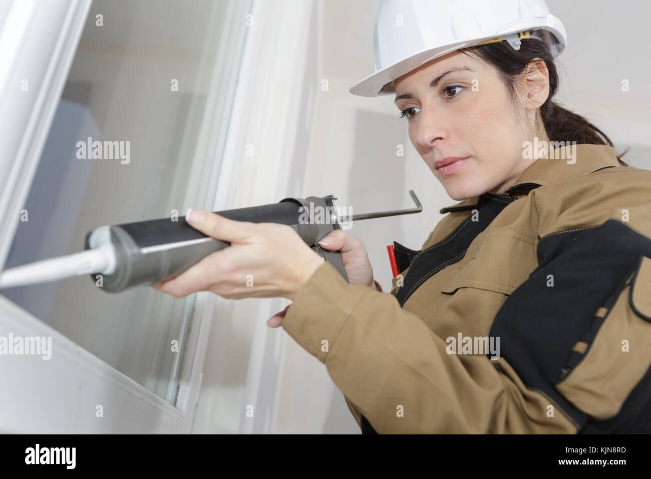 female construction worker installing window in house Stock Photo - Alamy