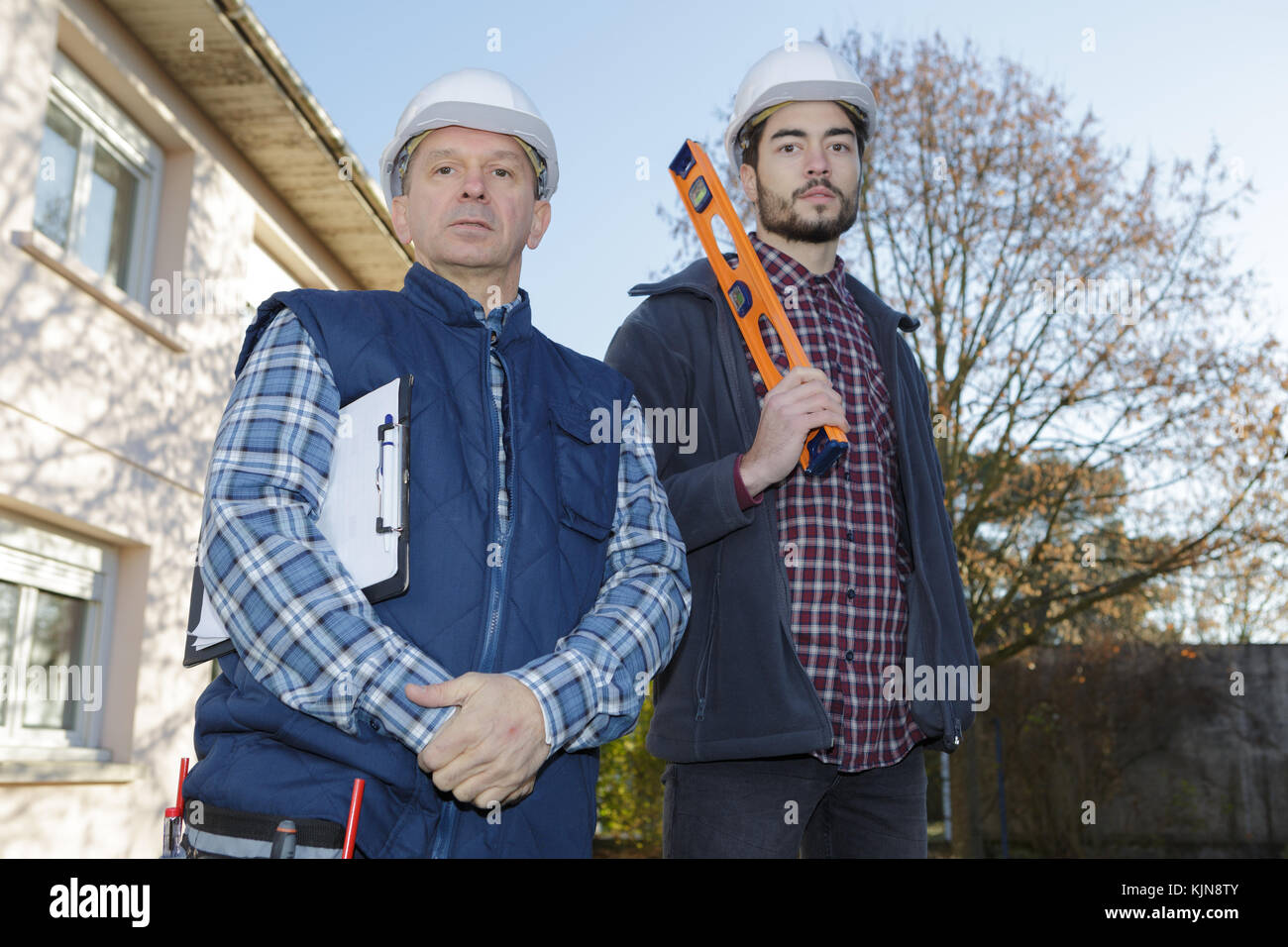 young man carrying a builders level in a construction site Stock Photo ...