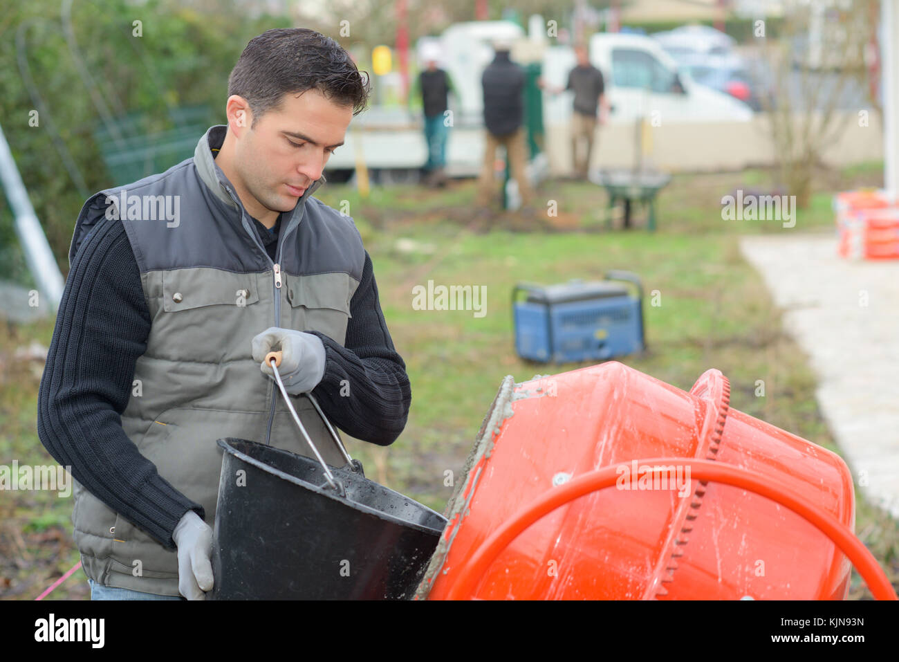 Man using a cement mixer Stock Photo - Alamy