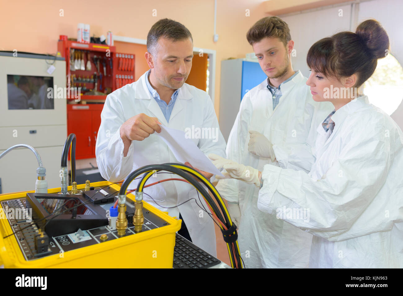 scientist looking at readings from machine Stock Photo - Alamy