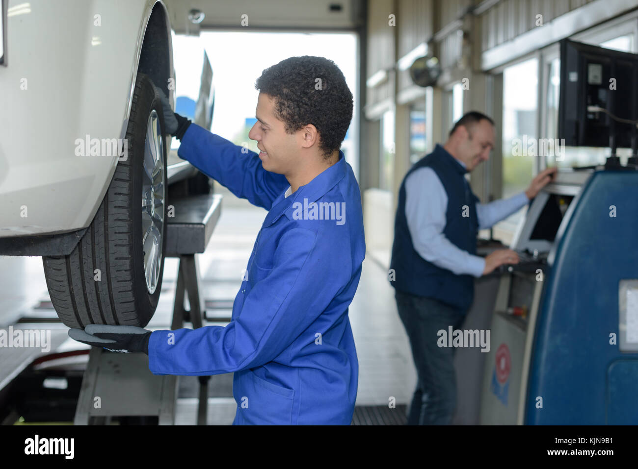 mechanic fixing a car wheel Stock Photo - Alamy
