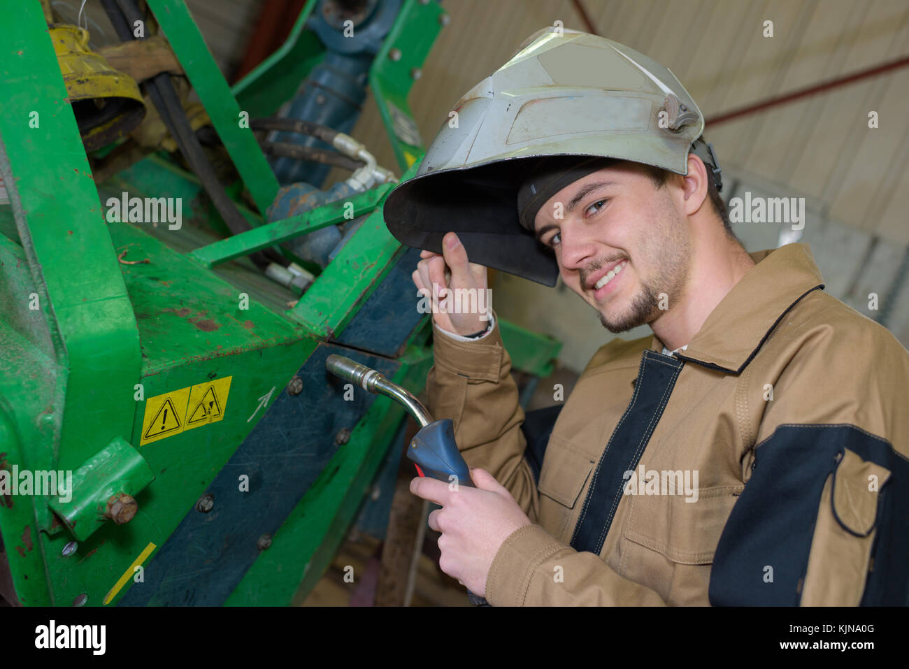happy apprentice welder at work in the plant Stock Photo - Alamy