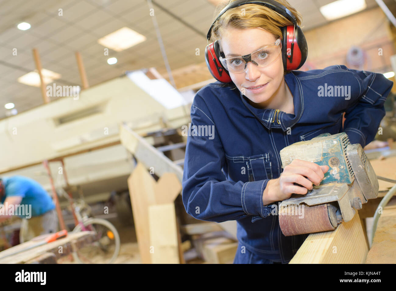 female carpenter using electric sander for wood Stock Photo - Alamy