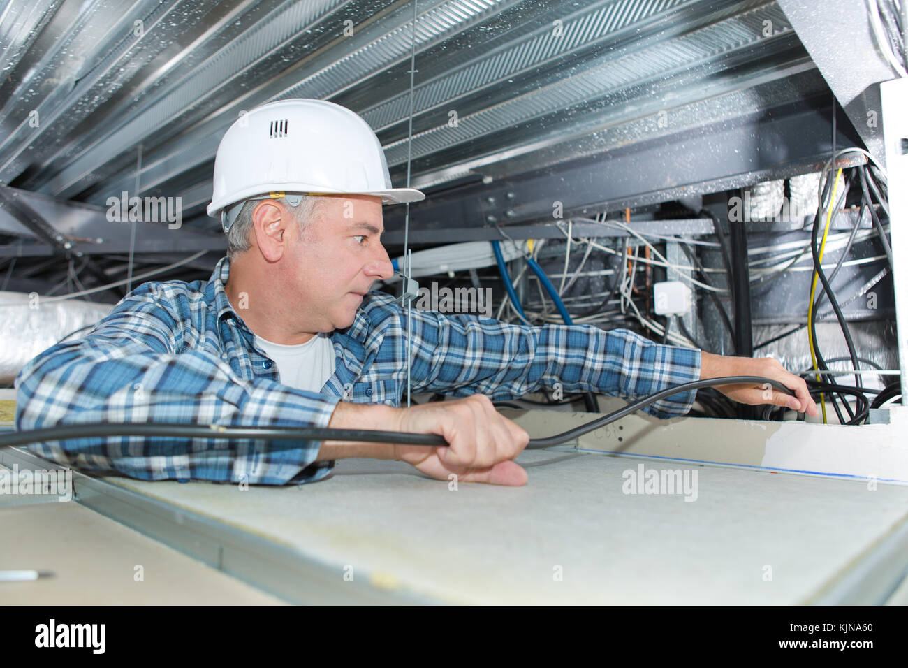 man repairing electrical wiring on the ceiling Stock Photo - Alamy