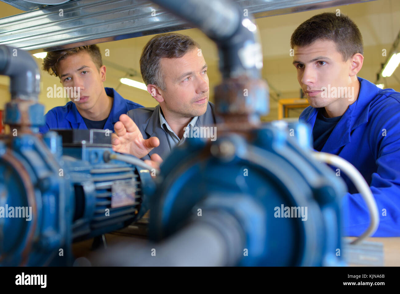 three men and a motor Stock Photo - Alamy