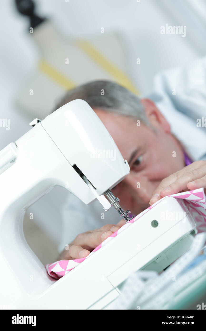 sewing process with old man designer Stock Photo - Alamy