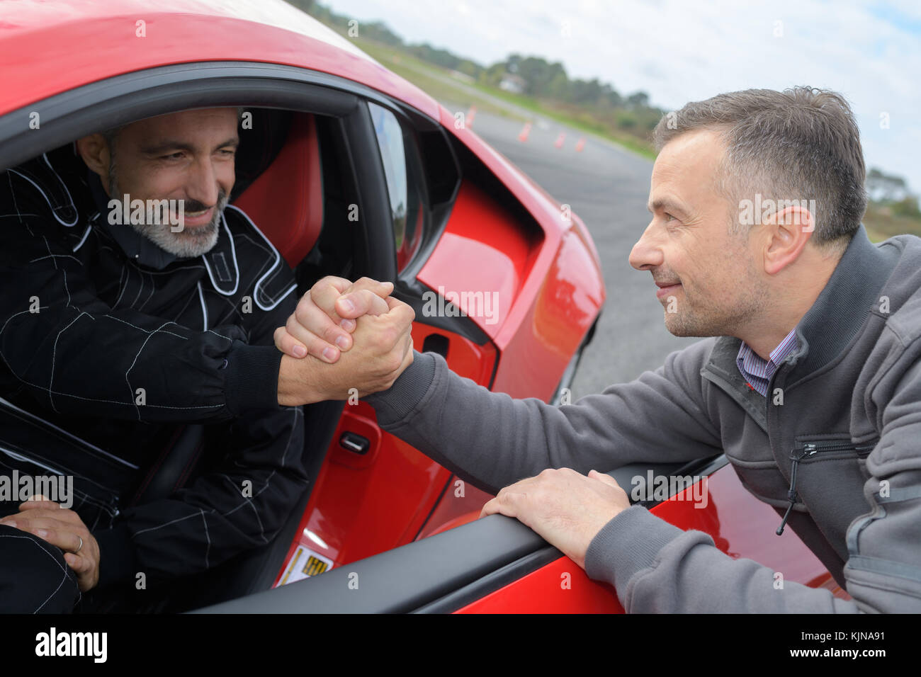 sportscar pilot shaking hands with his engineer on race track Stock ...
