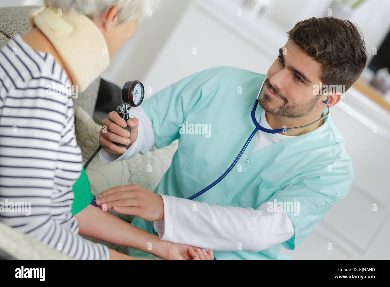 handsome doctor taking patients blood pressure Stock Photo - Alamy