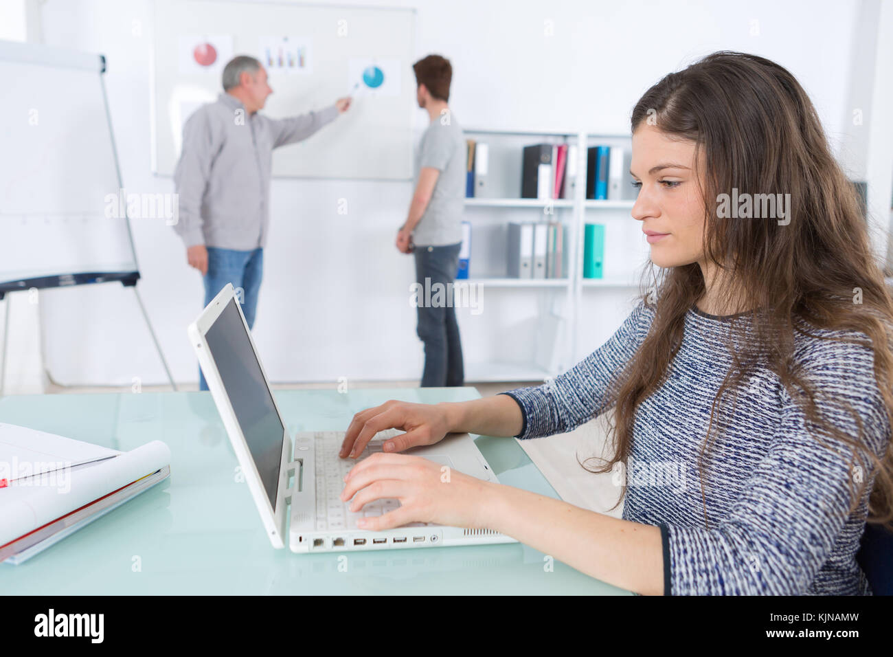 Female student typing, men at whiteboard in background Stock Photo - Alamy
