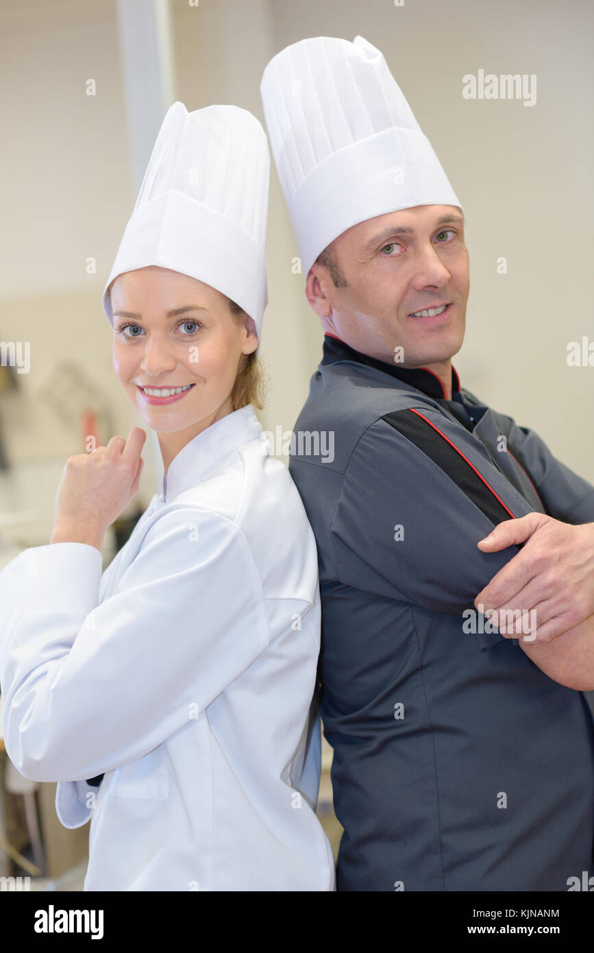 team of bakers posing back to back and smiling Stock Photo - Alamy