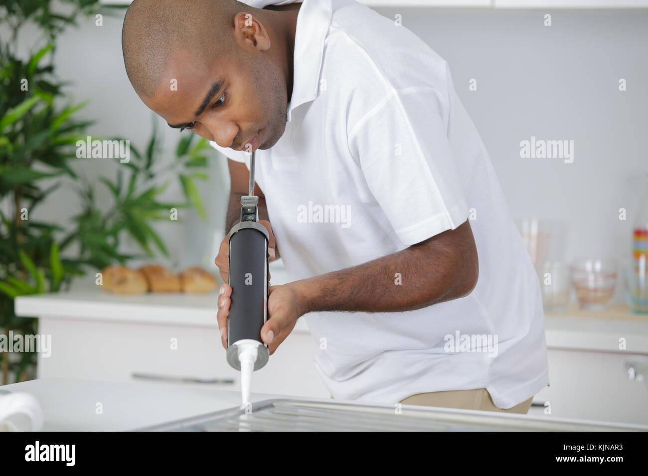 Workman using silicone gun Stock Photo - Alamy