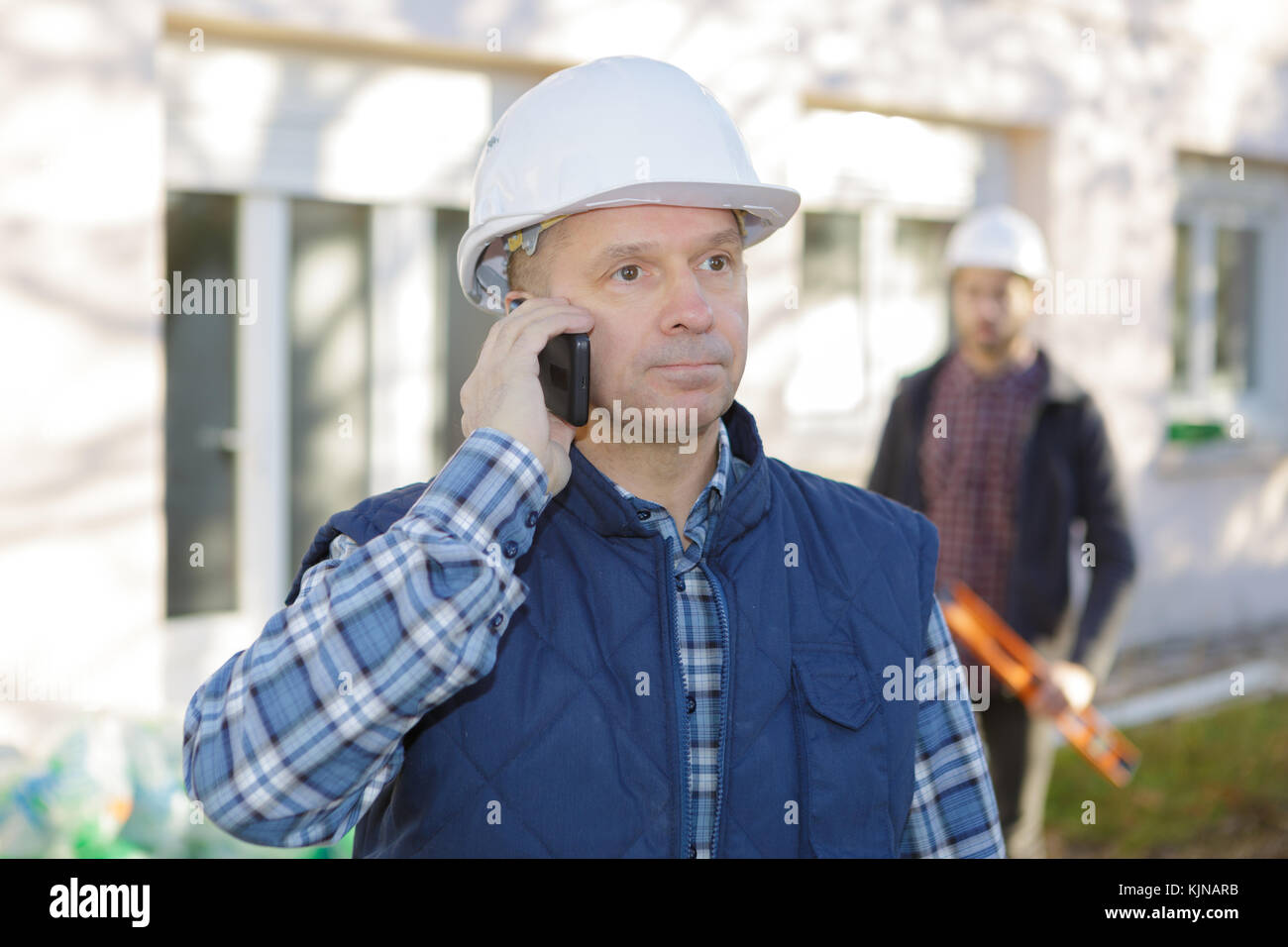 construction engineer talking by phone on building site Stock Photo - Alamy